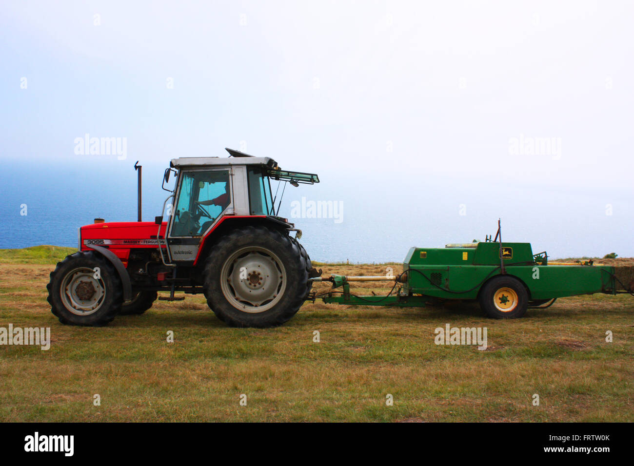 A red tractor cutting grass Stock Photo - Alamy