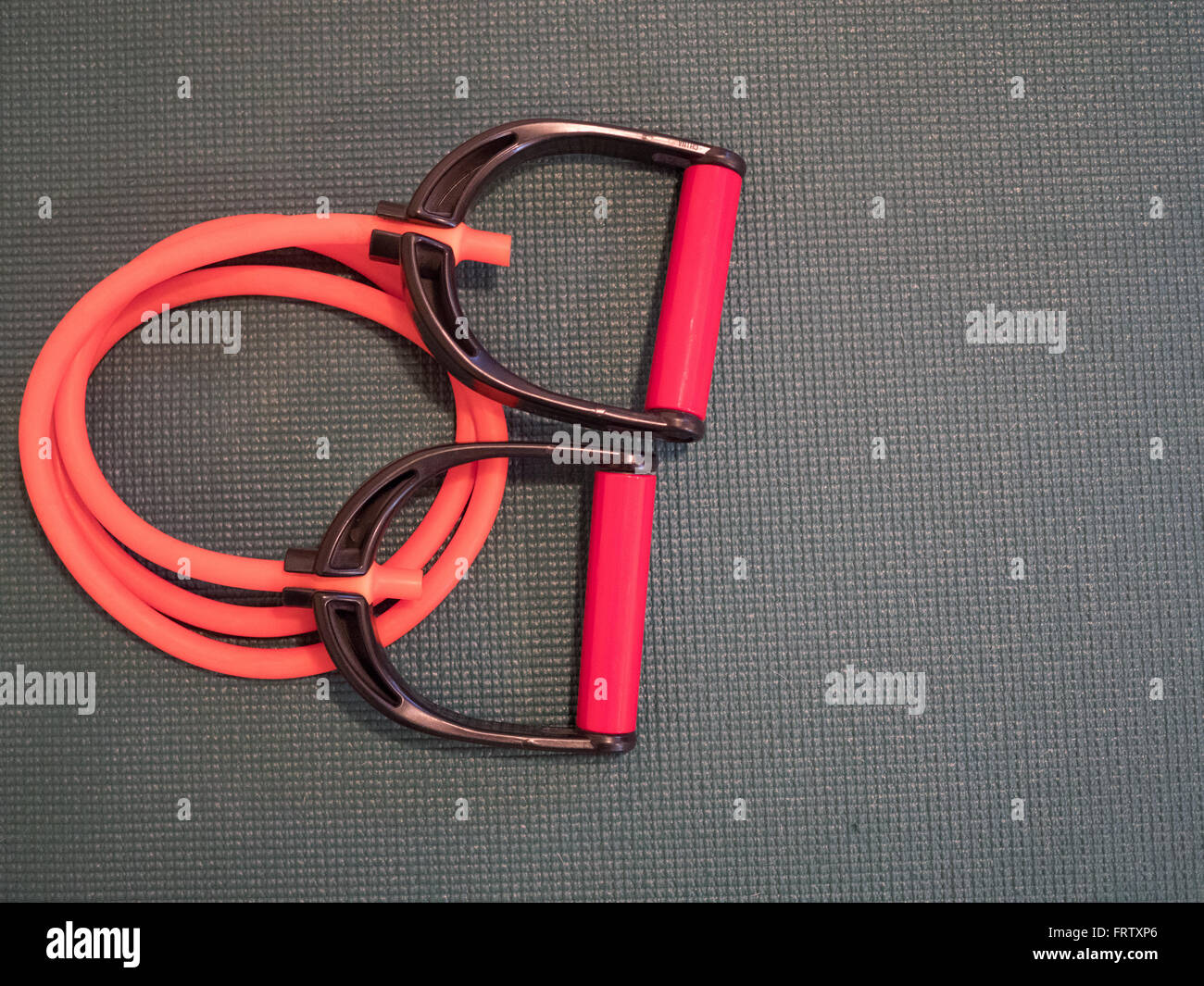 Single orange resistance tube with black and red handles Stock Photo ...