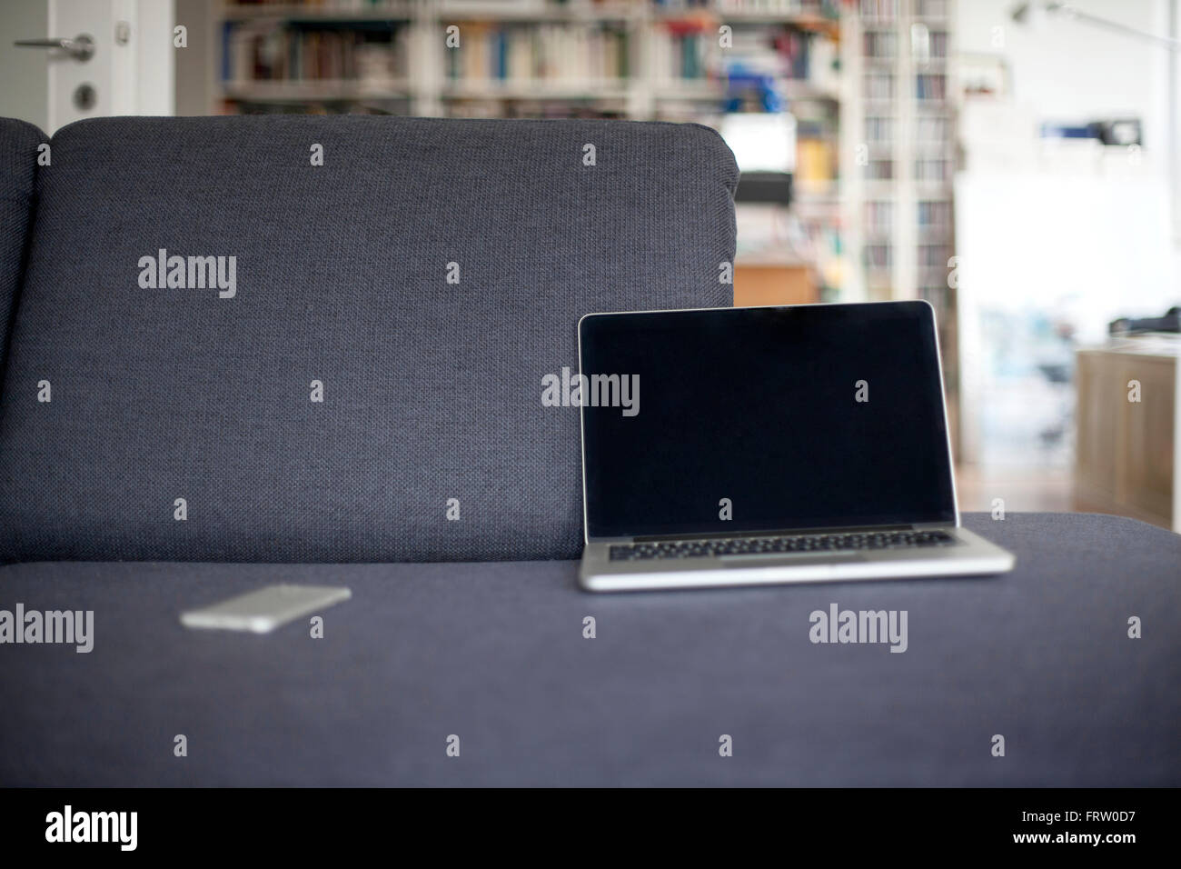 Laptop on couch Stock Photo - Alamy