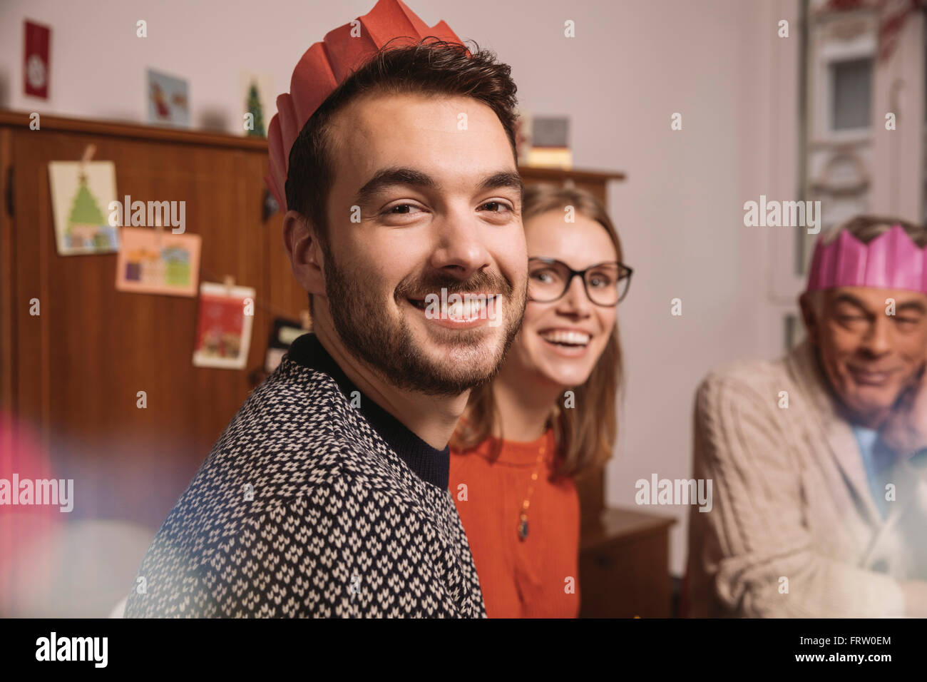 Smiling man wearing paper crown with family in background Stock Photo ...