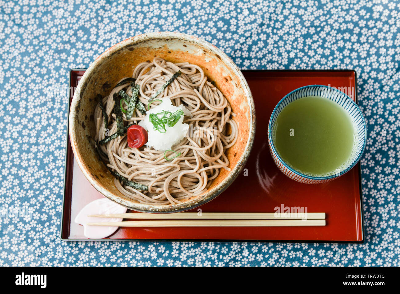 Bowl of Soba noodles on red lacquer plate and bowl of green tea Stock ...