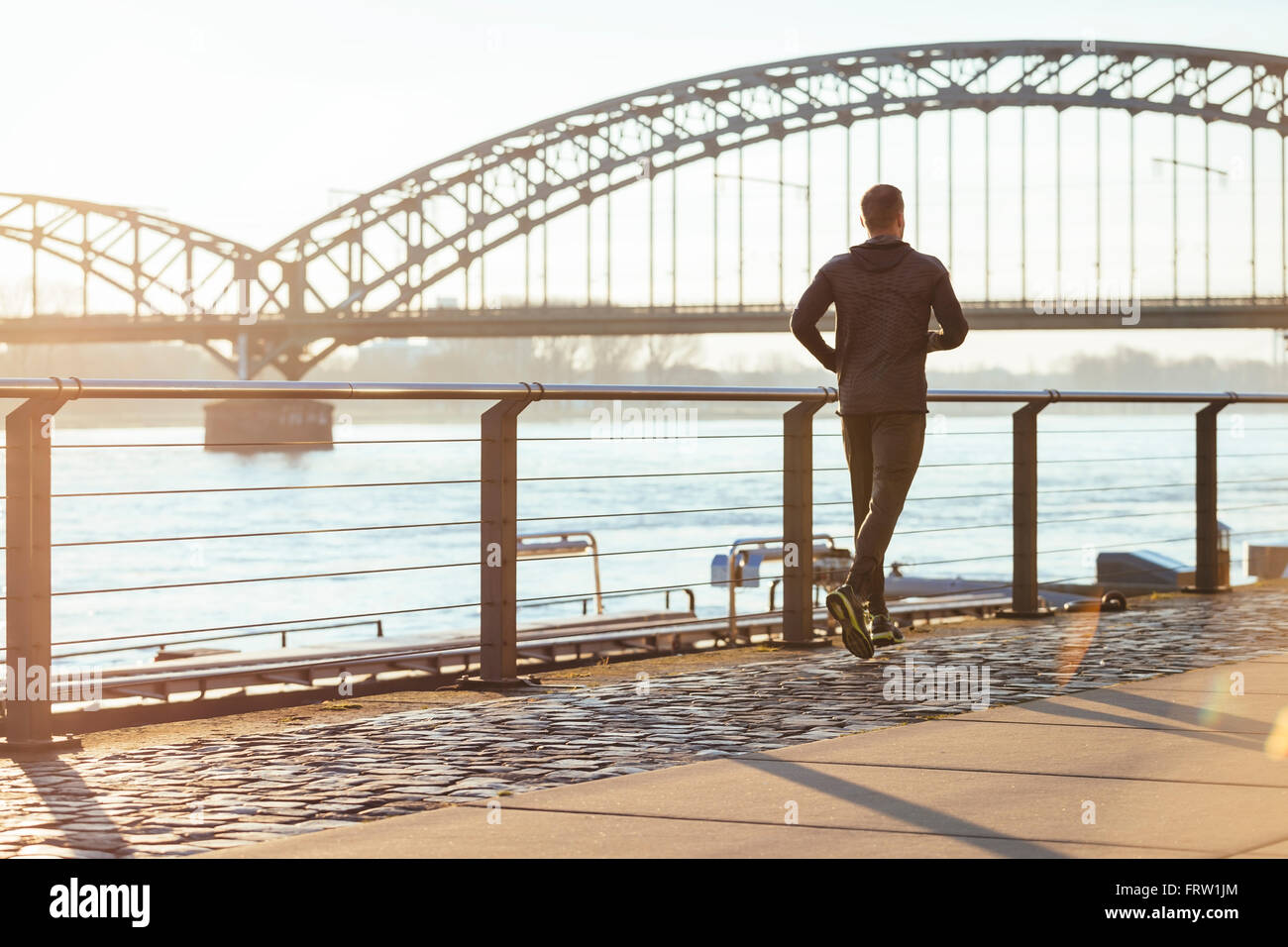 Germany, Cologne, Young man running at the riverside Stock Photo - Alamy