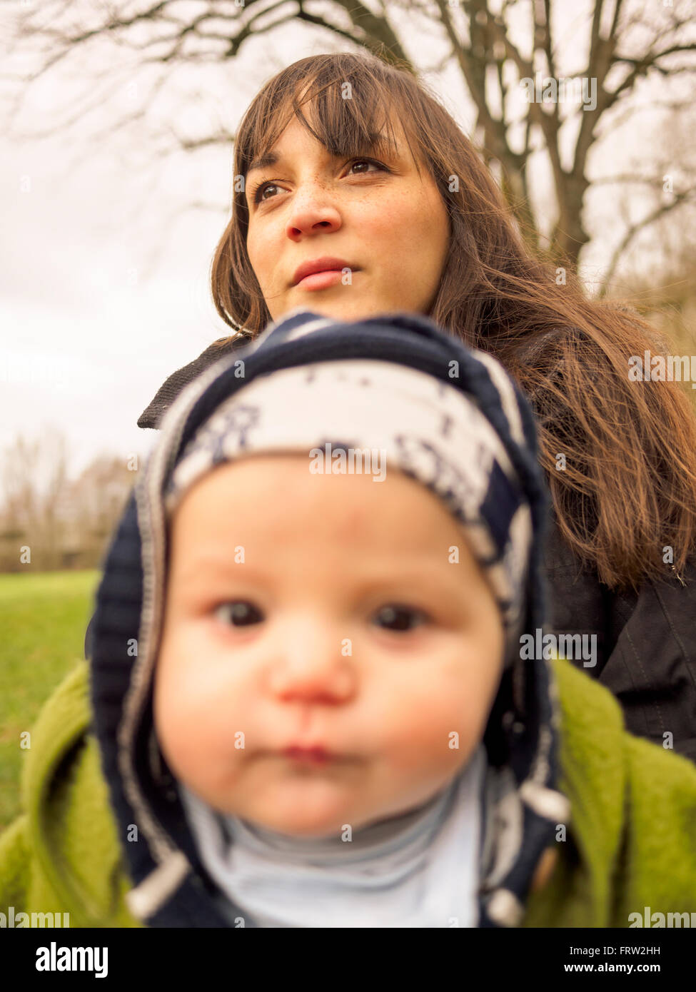 Thoughtfulness mother looking at distance while her little son watching ...