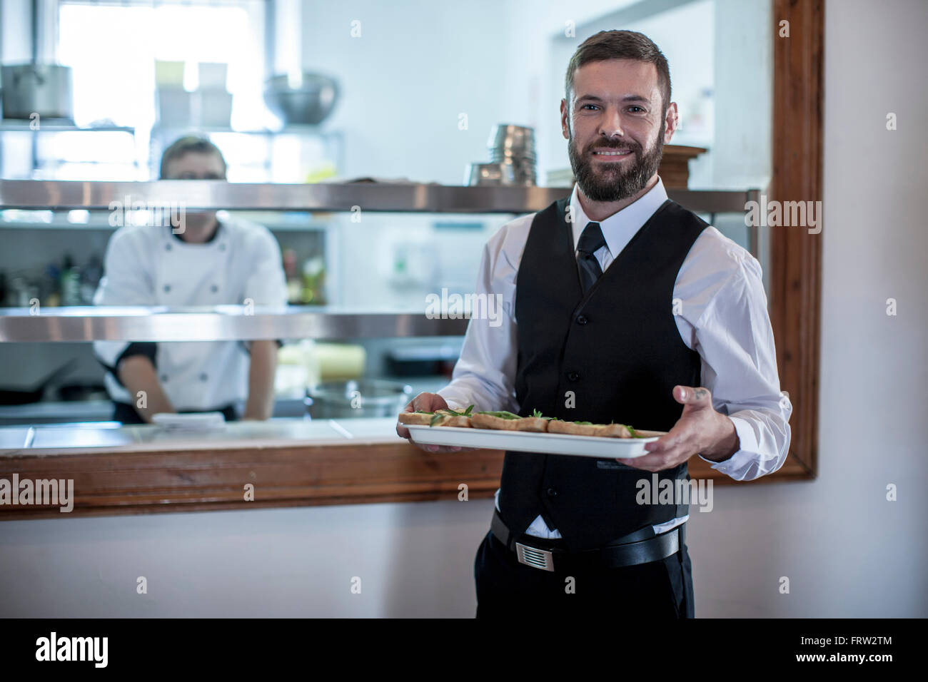 Waiter picking up food from the kitchen Stock Photo - Alamy