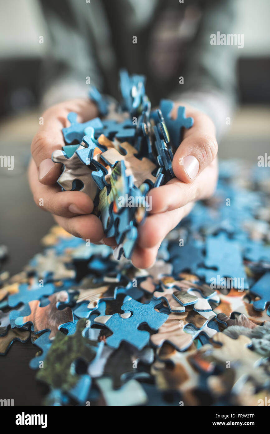 Boy's hands holding jigsaw pieces Stock Photo - Alamy