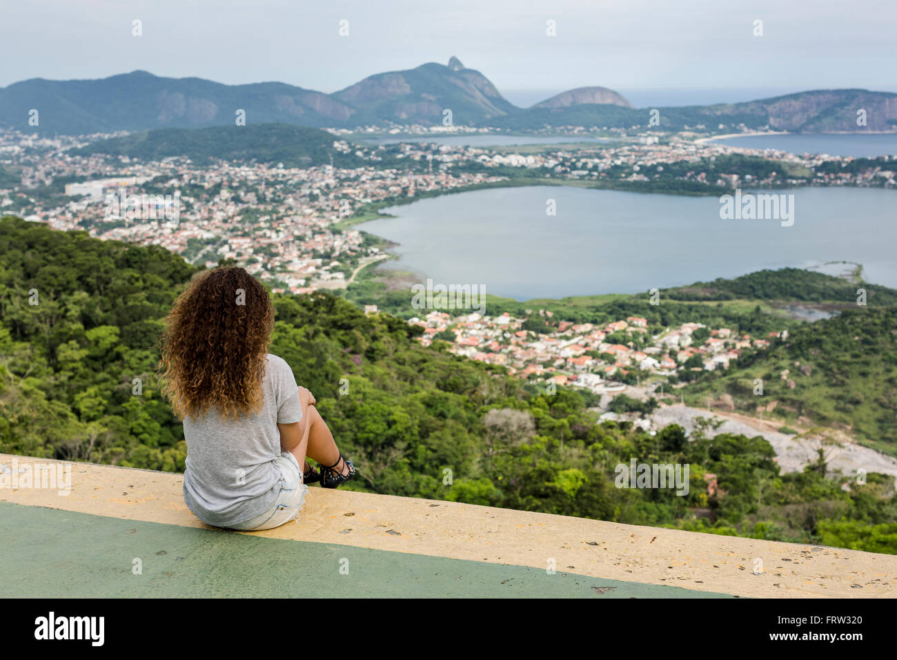 Brazil, woman sitting on a viewpoint in Rio de Janeiro Stock Photo - Alamy