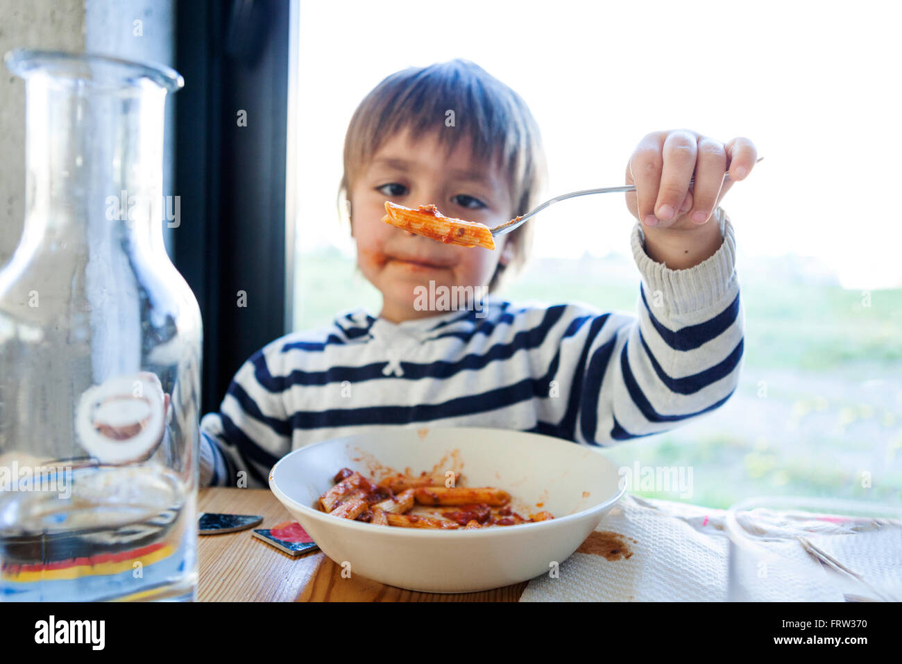 Boy eating pasta with tomato sauce Stock Photo - Alamy