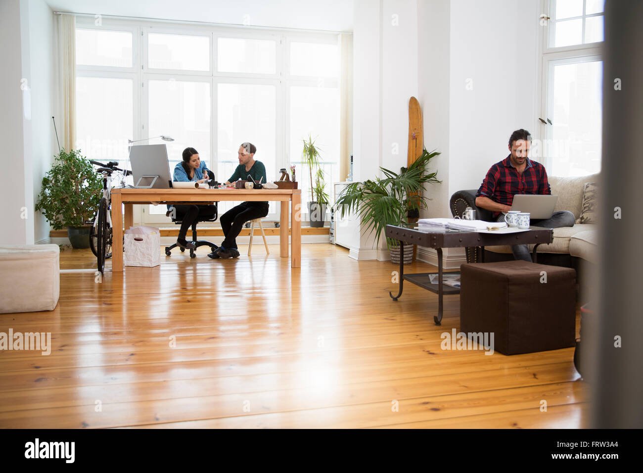 Three creative business people working in informal office Stock Photo ...