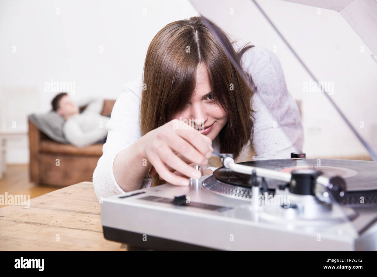 Young woman operating record player Stock Photo - Alamy