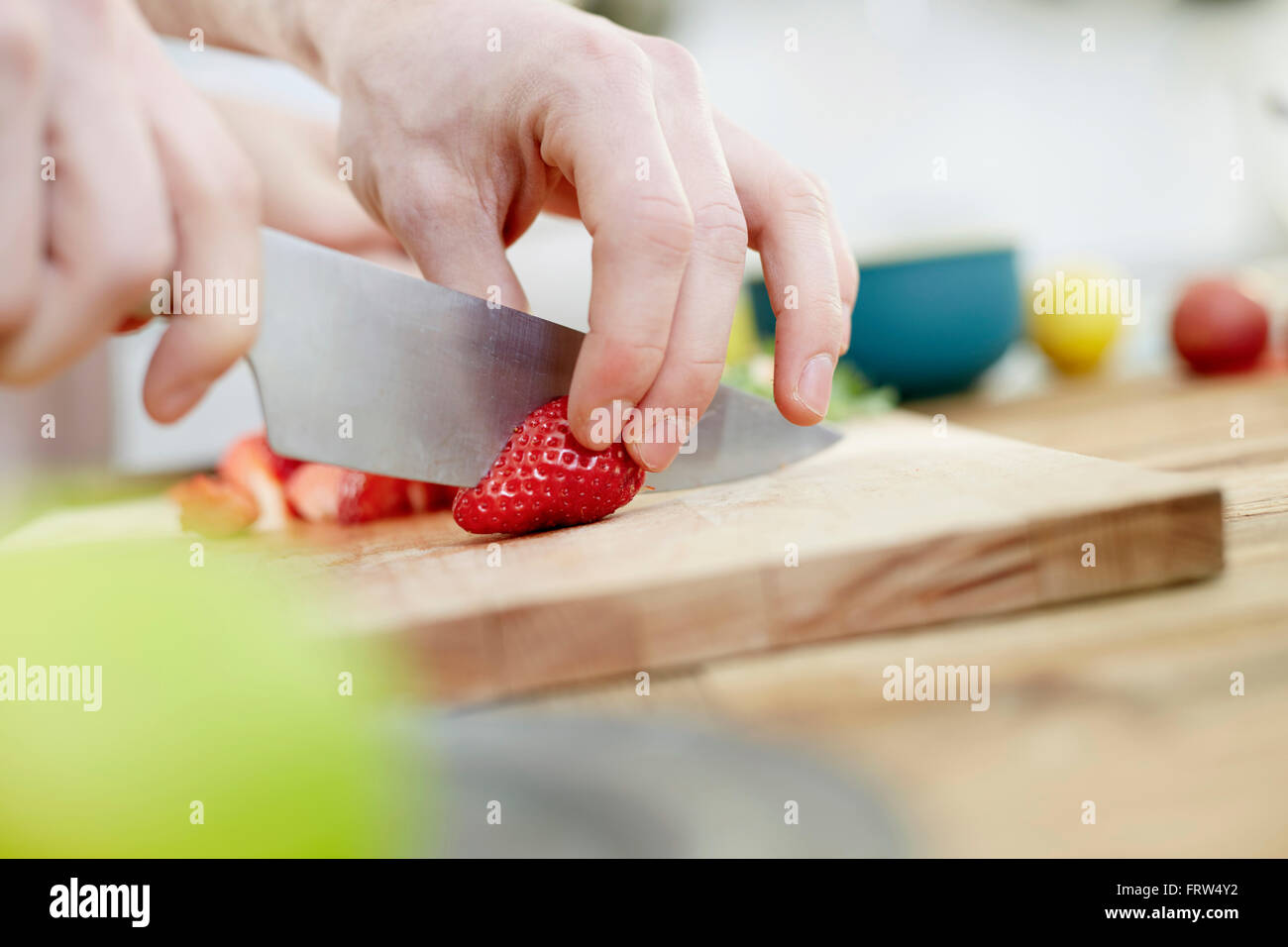 Man cutting strawberries in kitchen Stock Photo - Alamy