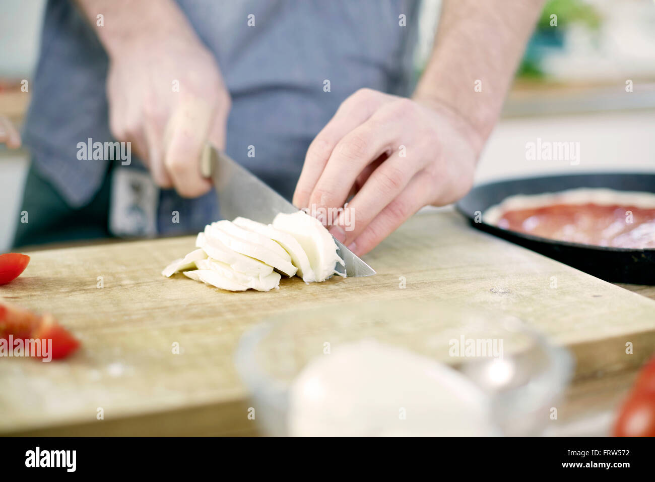 Man slicing mozzarella on chopping board Stock Photo - Alamy