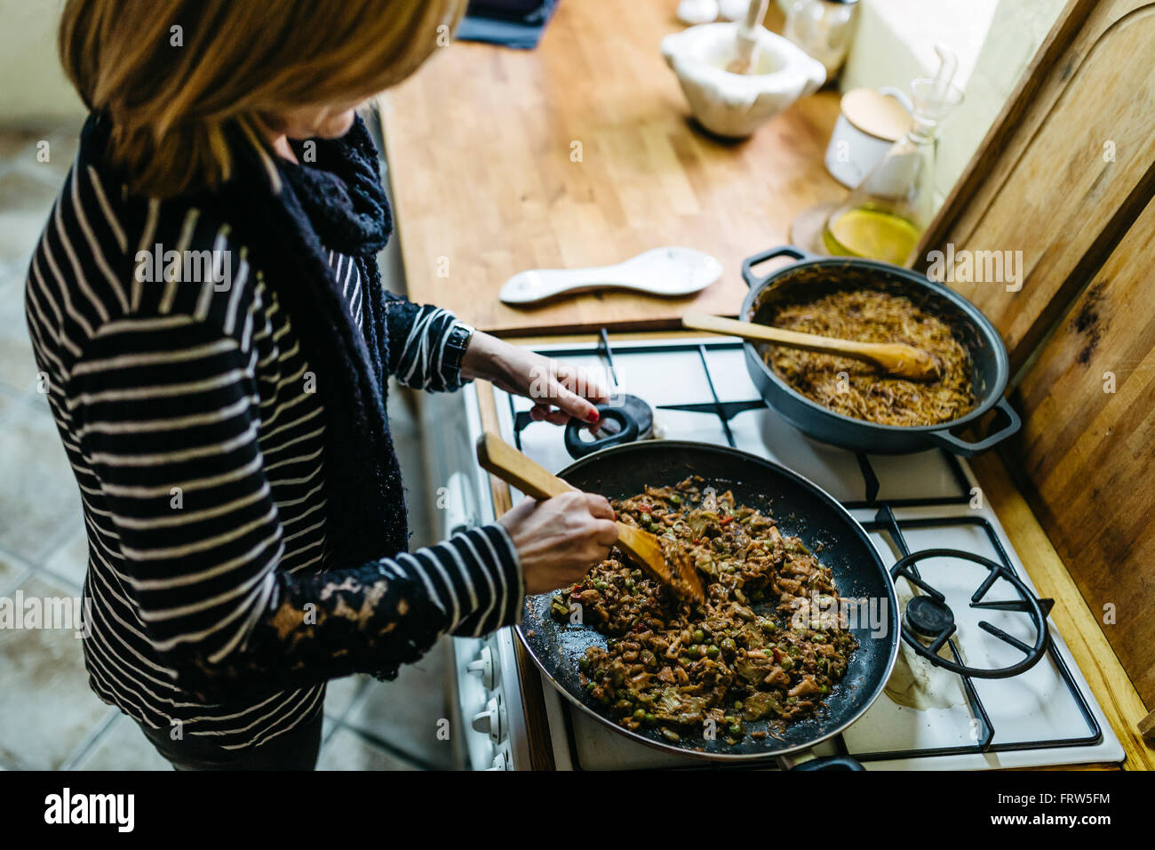 Woman cooking on gas stove in her kitchen Stock Photo - Alamy