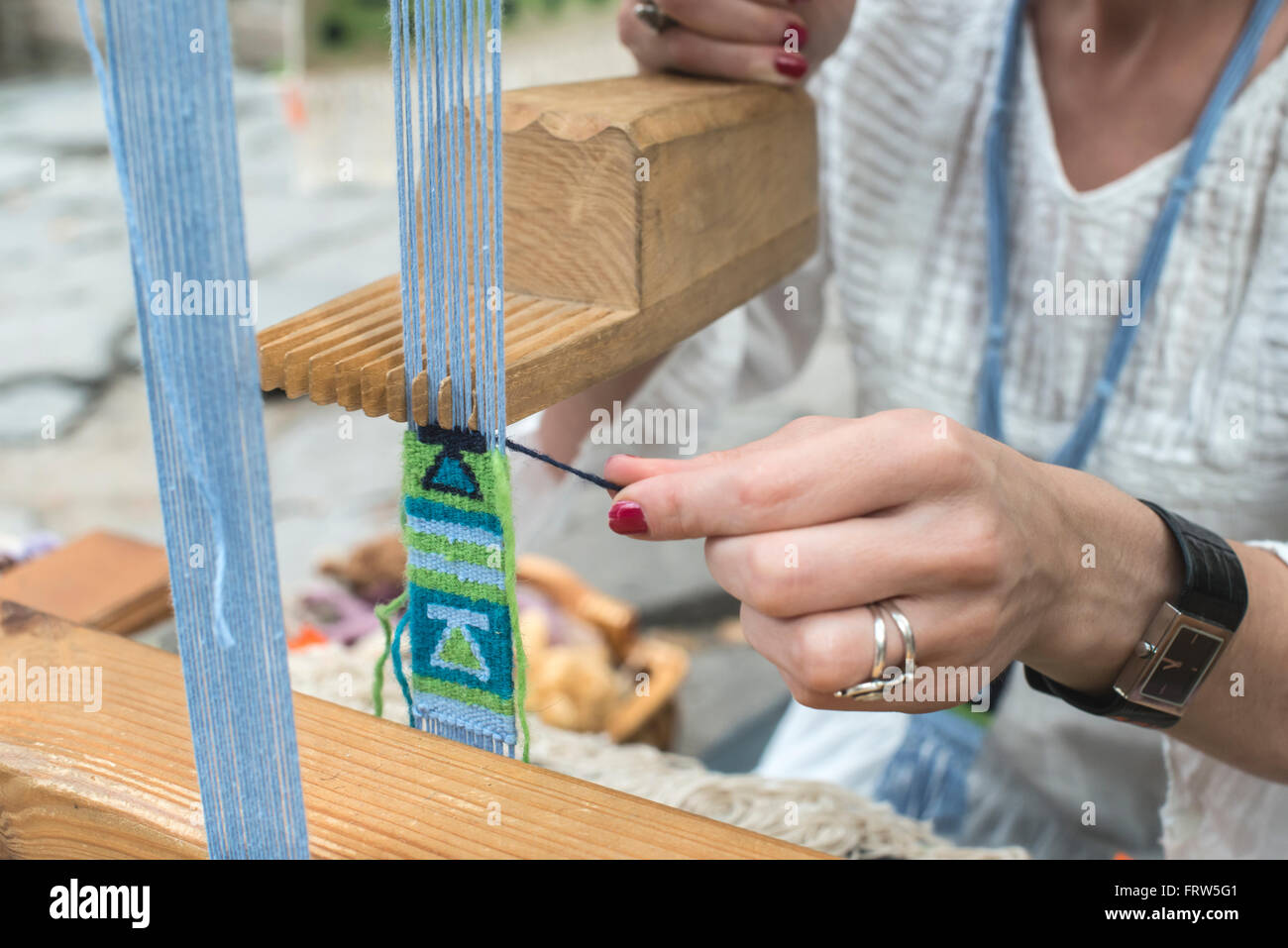 Woman weaving carpet with weaving loom Stock Photo - Alamy