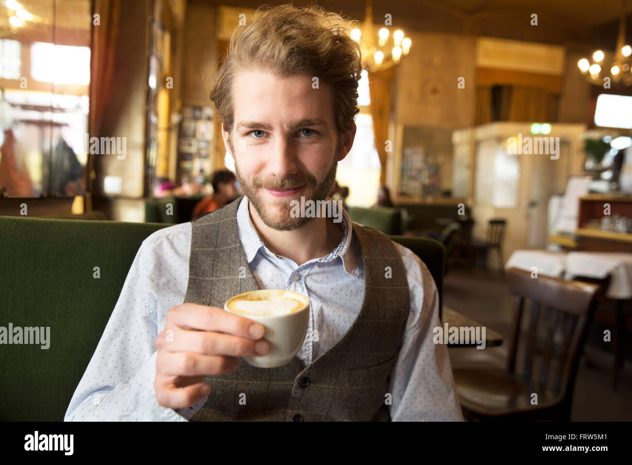 Portrait of smiling young man in a cafe Stock Photo - Alamy