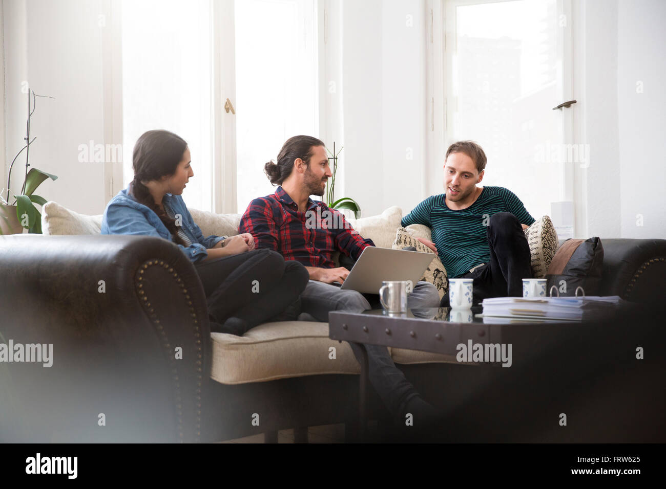 Three creative business people working in informal office Stock Photo ...