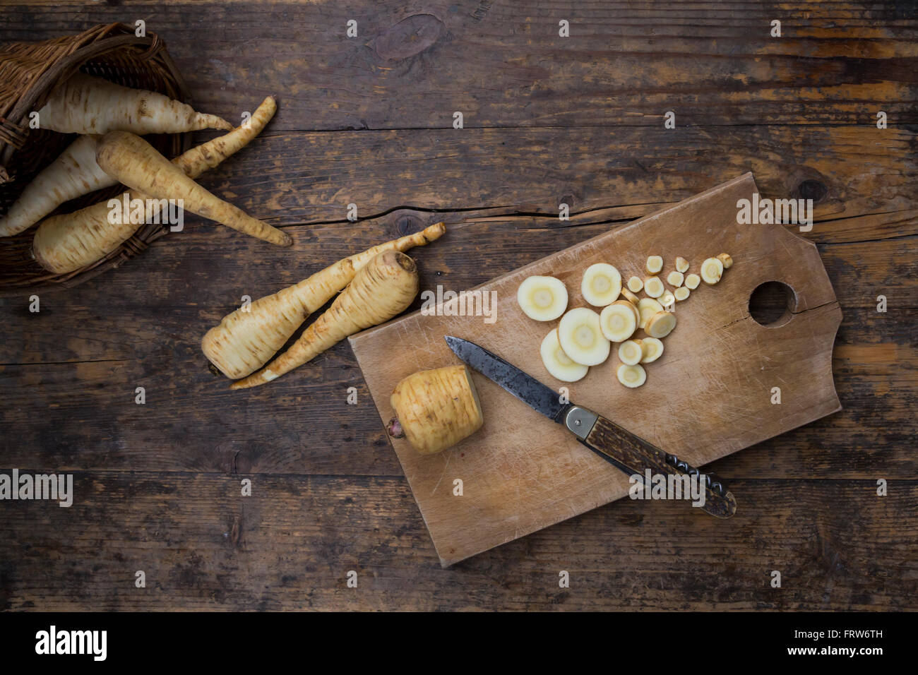 Sliced organic parsnips and pocket knife on chopping board Stock Photo ...