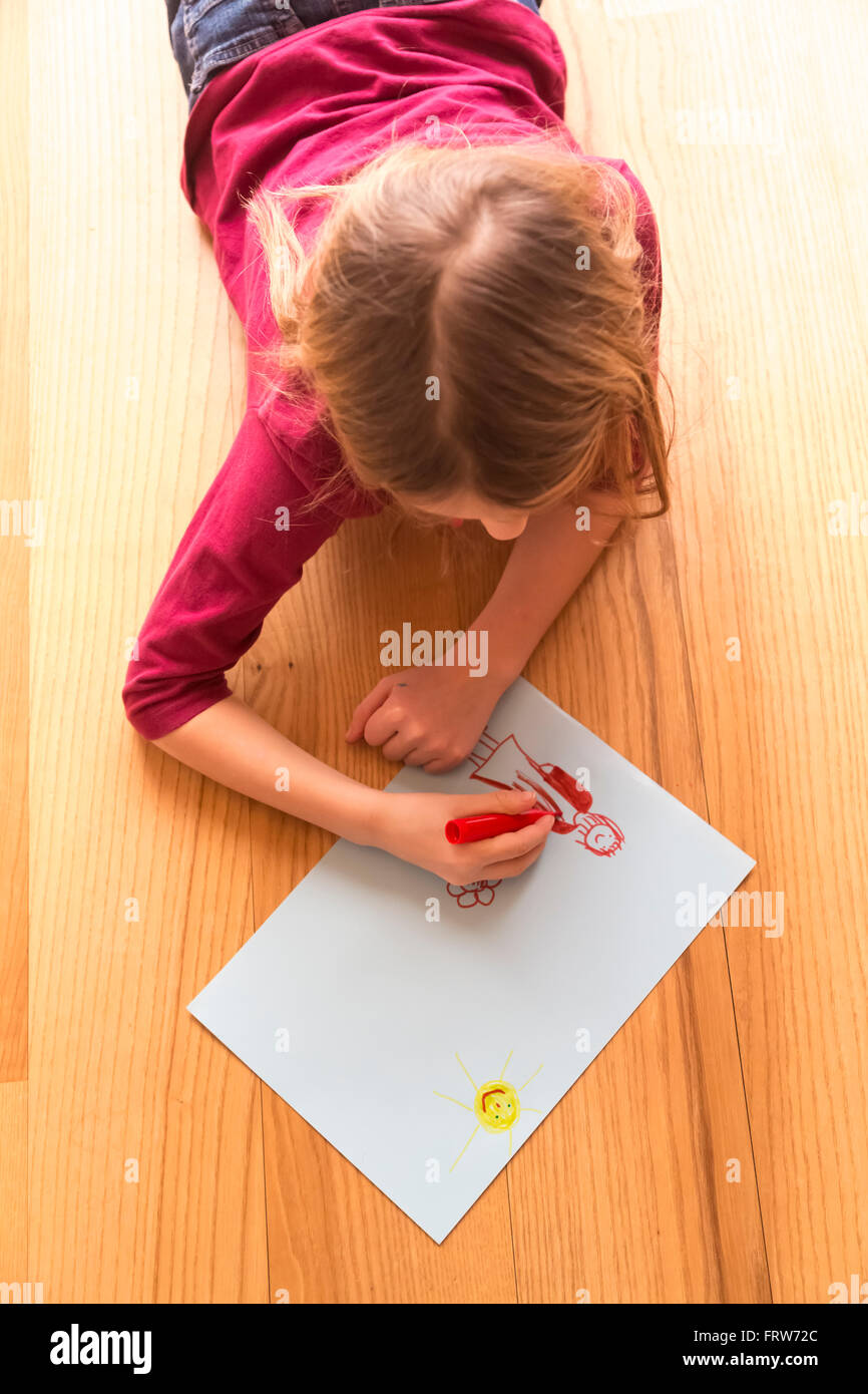 Drawing girl lying on wooden floor Stock Photo - Alamy