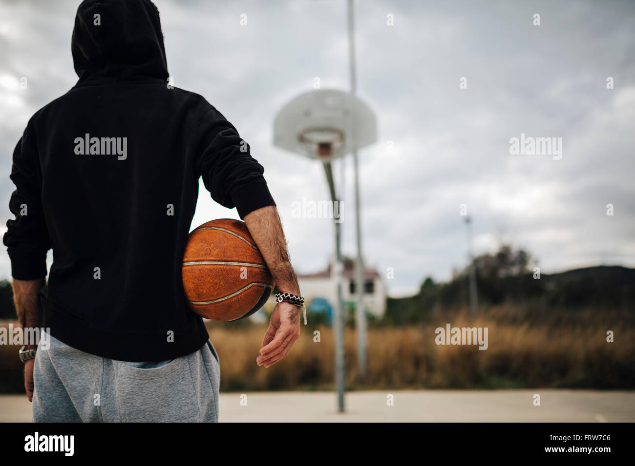 Man playing with basketball on an outdoor court Stock Photo - Alamy
