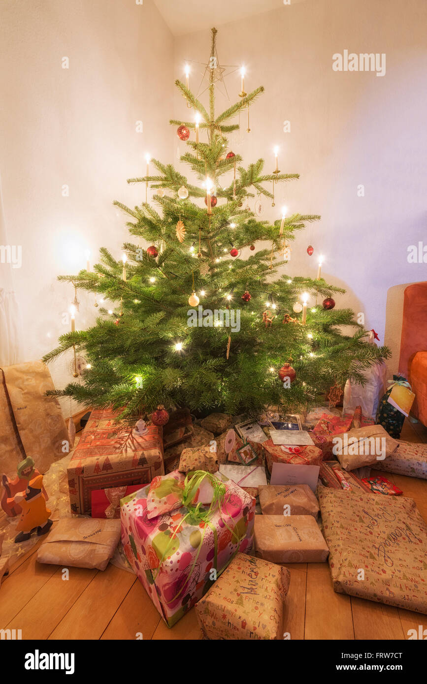 Lighted Christmas tree and Christmas presents Stock Photo - Alamy