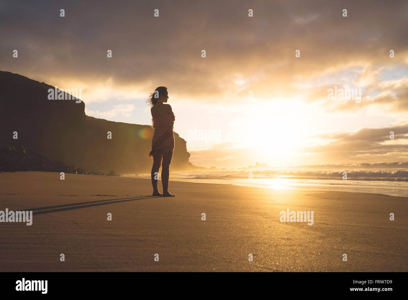 Woman standing on the beach at sunset Stock Photo - Alamy