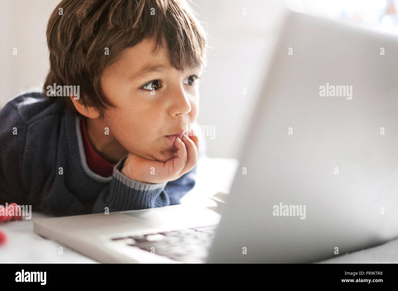 Portrait of little boy staring at laptop Stock Photo - Alamy