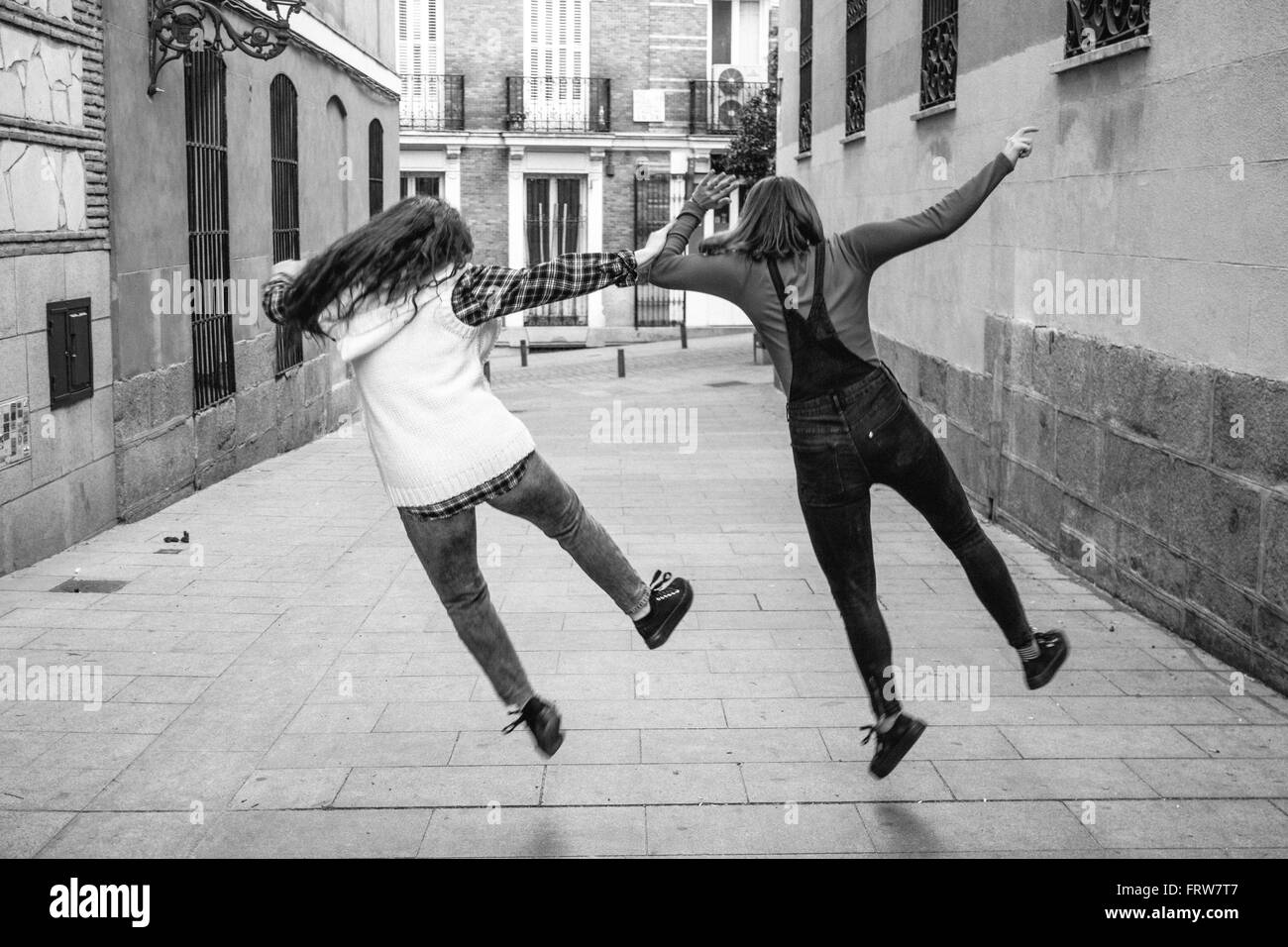 Back view two young women jumping in Black and White Stock Photos ...