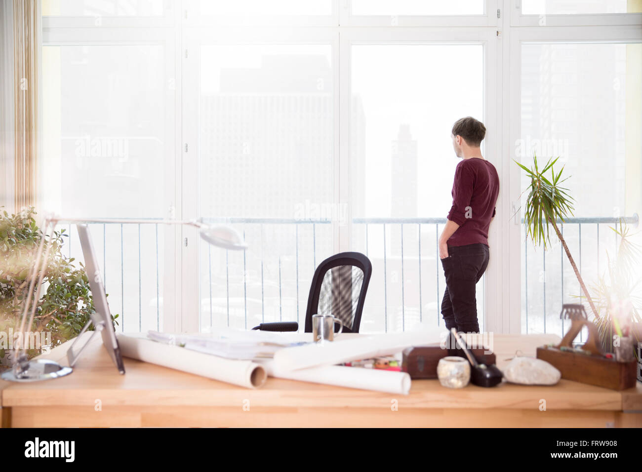 Man in office looking out of window Stock Photo - Alamy