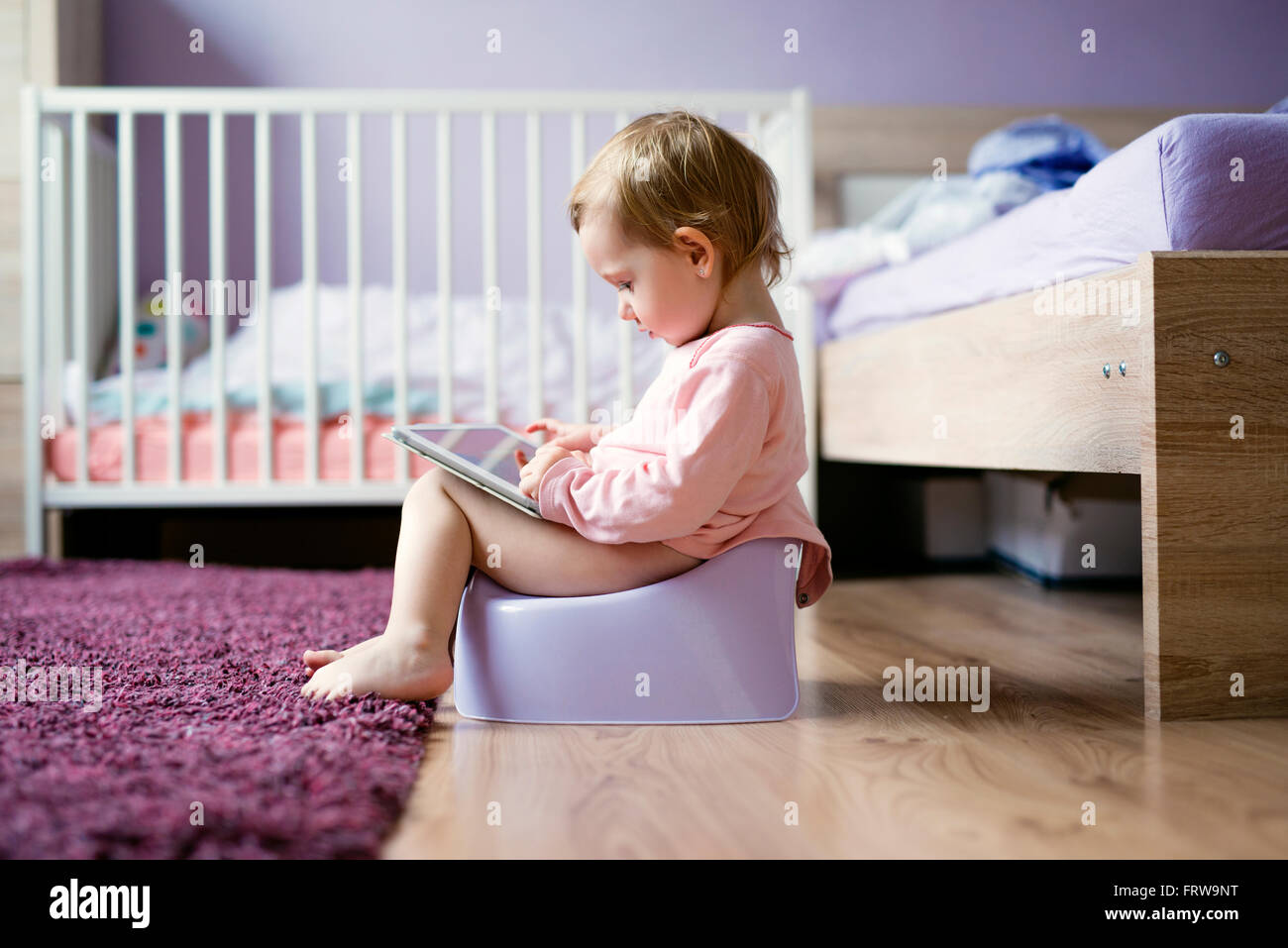 Toddler sitting on potty playing with digital tablet Stock Photo - Alamy