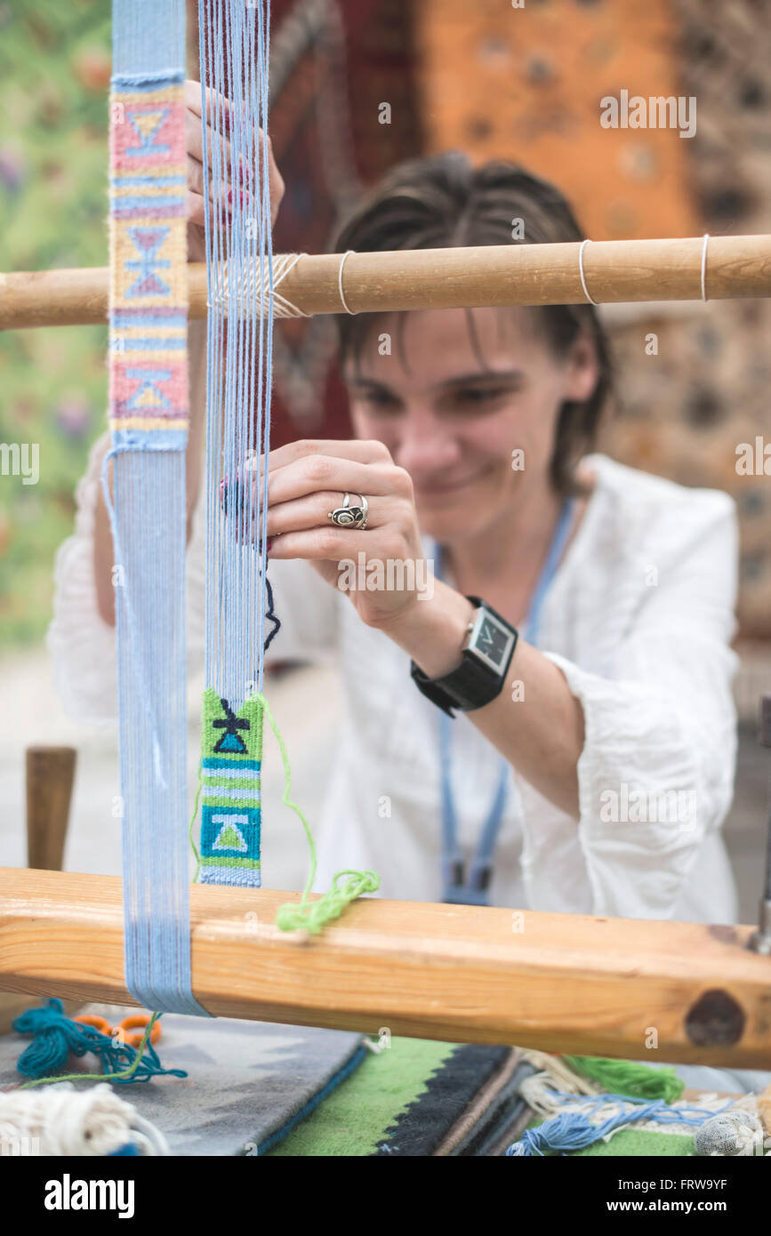 Woman weaving carpet with weaving loom Stock Photo - Alamy