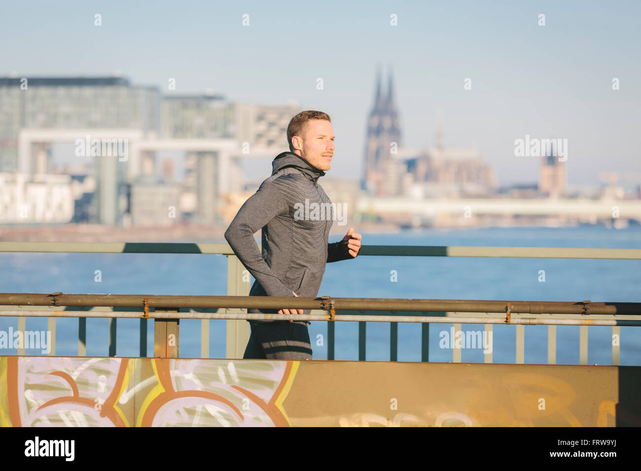 Germany, Cologne, Young man running at the riverside Stock Photo - Alamy