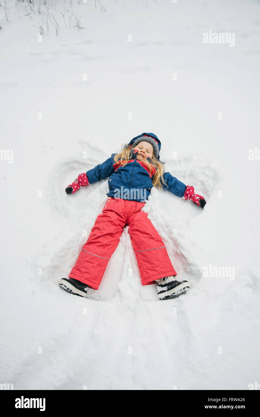 Little girl making a snow angel Stock Photo - Alamy
