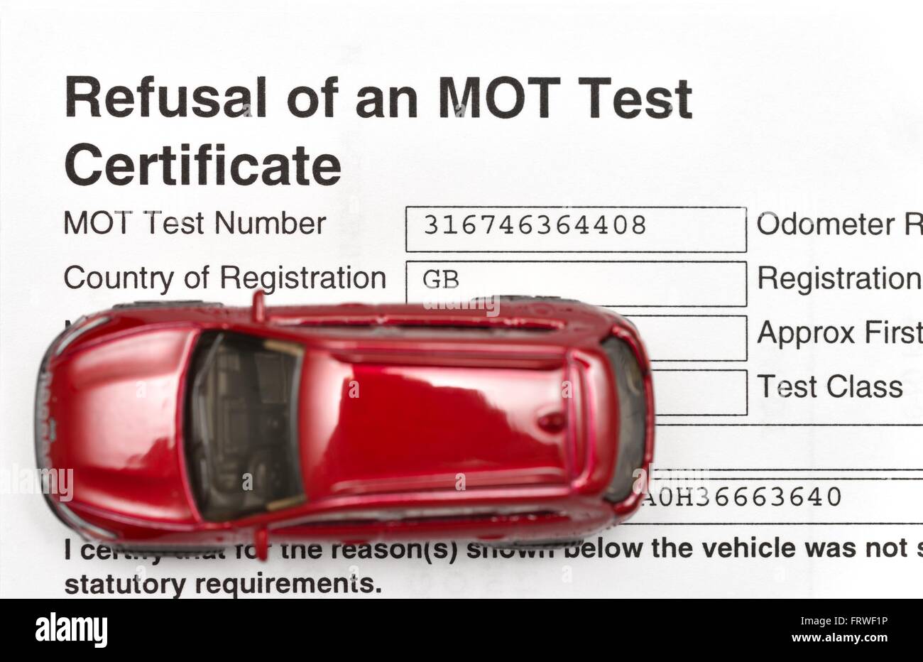 Refusal of an MOT test certificate document and a red miniature car ...