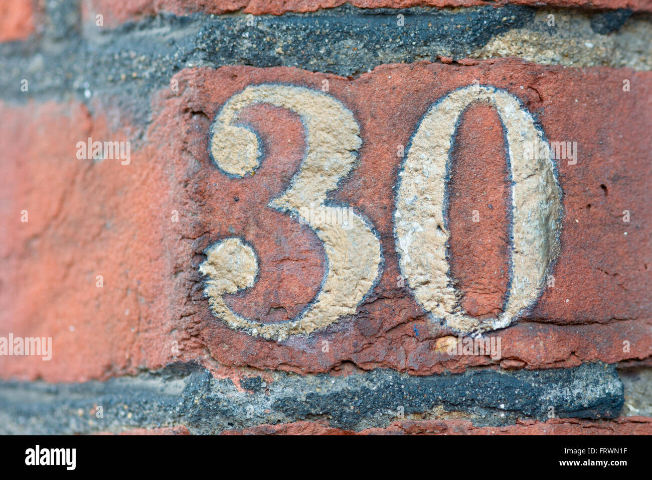 House number 30 sign painted gold on red brick wall Stock Photo - Alamy