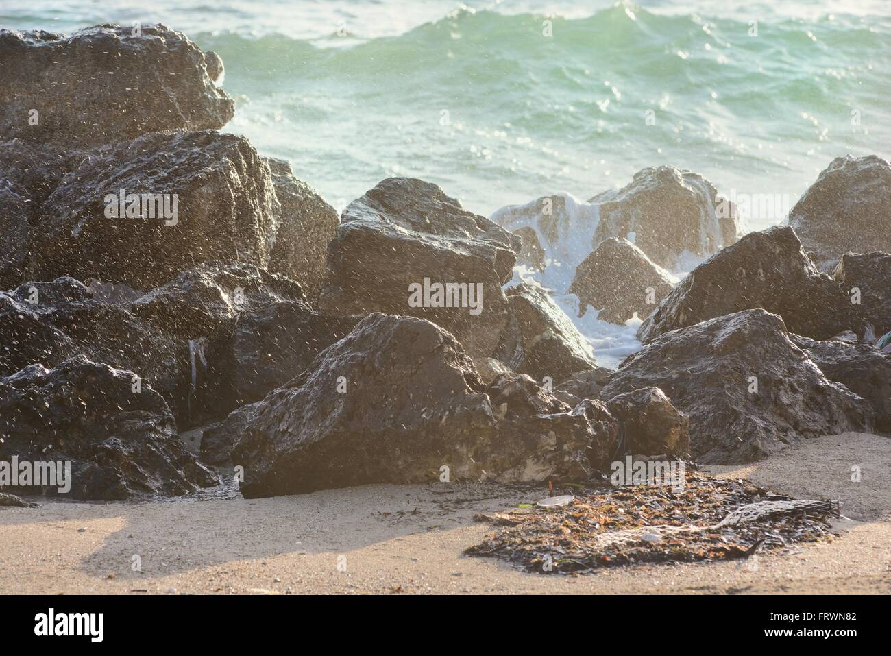 Water flowing over rocks on the beach Stock Photo - Alamy
