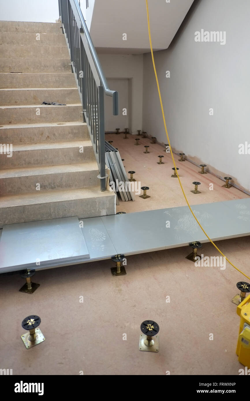 New raised access floor being installed at the base of a staircase ...