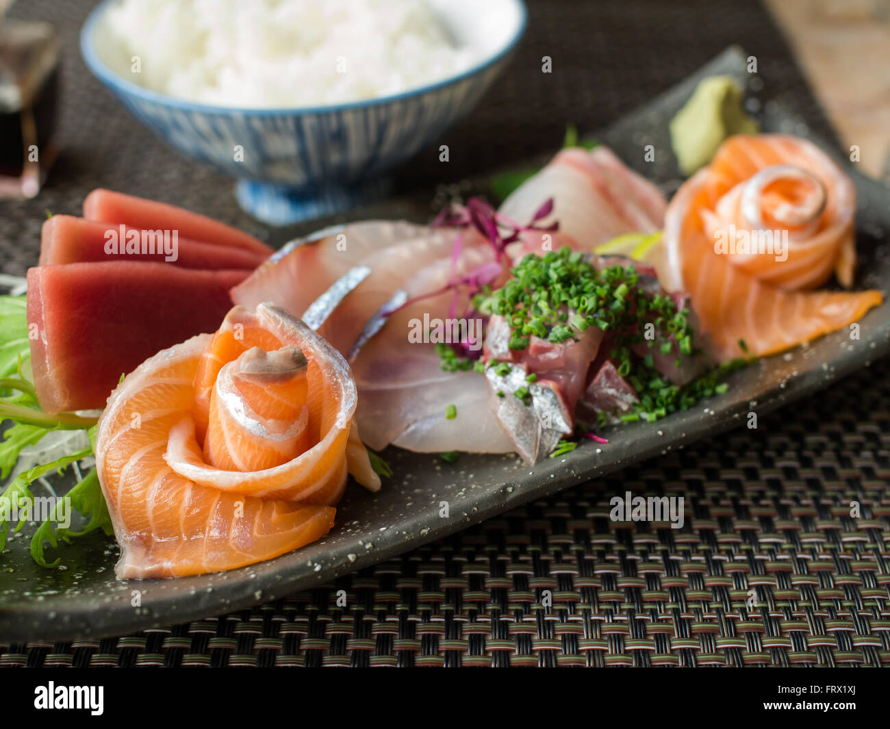 Japanese raw fish on black plate. Also known as Sashimi Stock Photo - Alamy