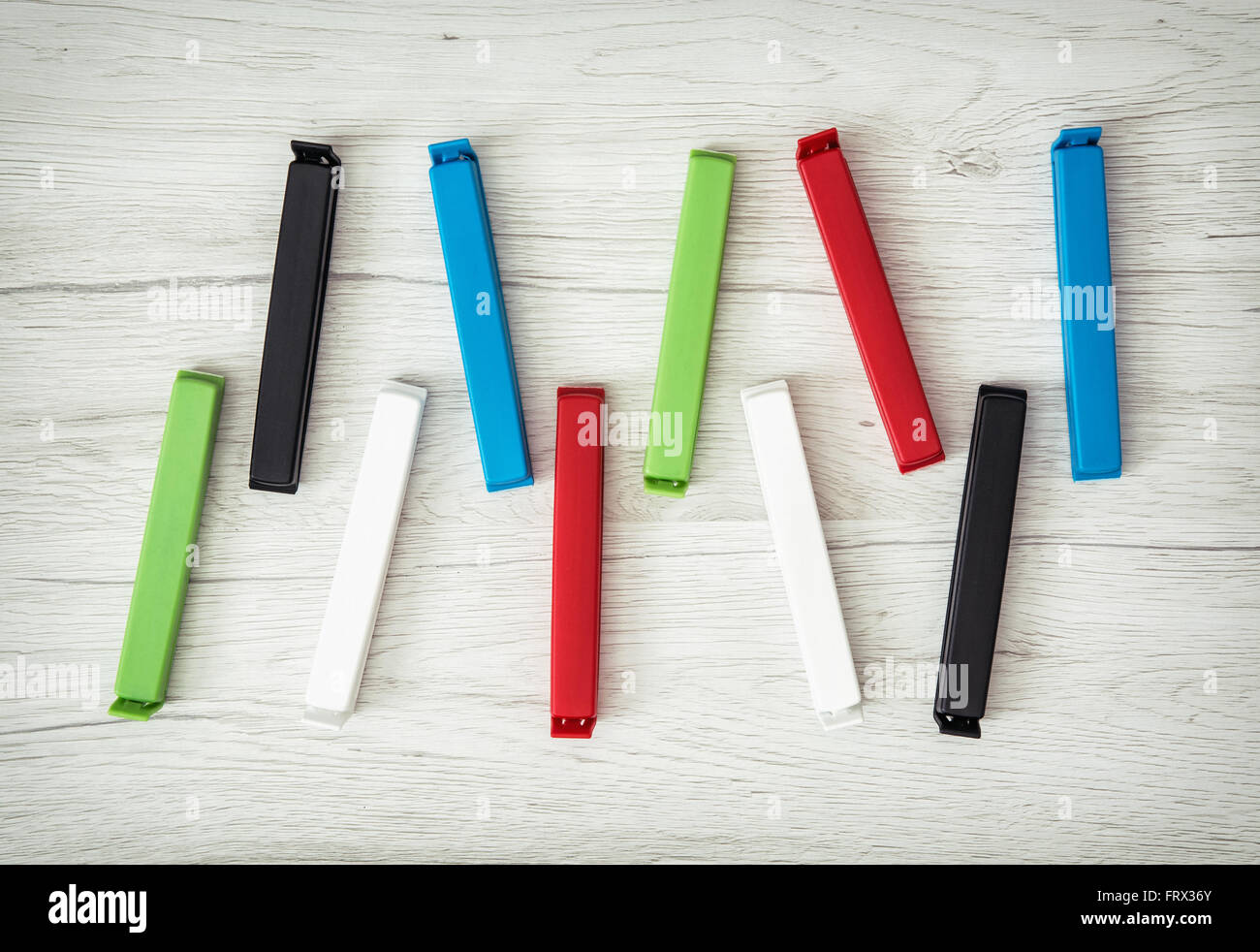 Various colorful bag clips on the wooden background Stock Photo - Alamy