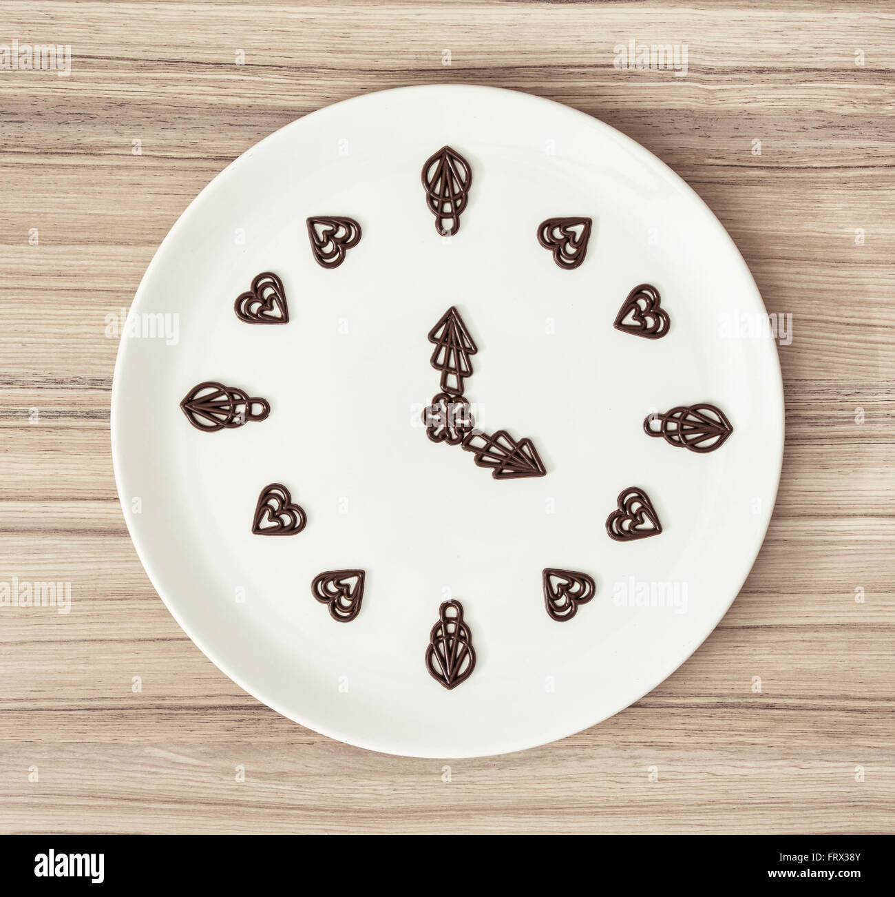 Dark chocolate garnishes in the shape of the clock. Symbolic food Stock ...