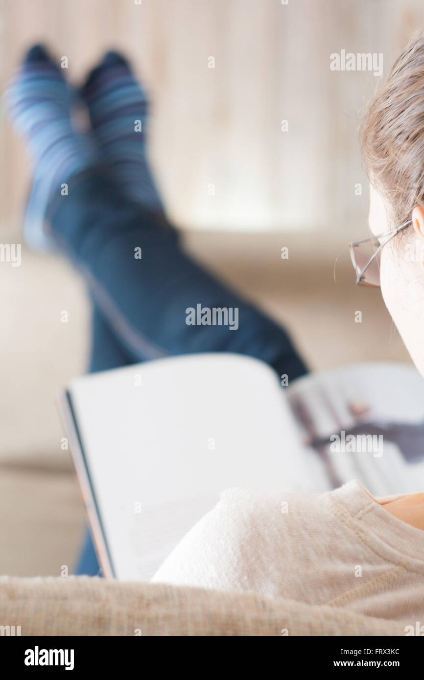 Young woman reading magazine book relaxed in sofa Stock Photo - Alamy