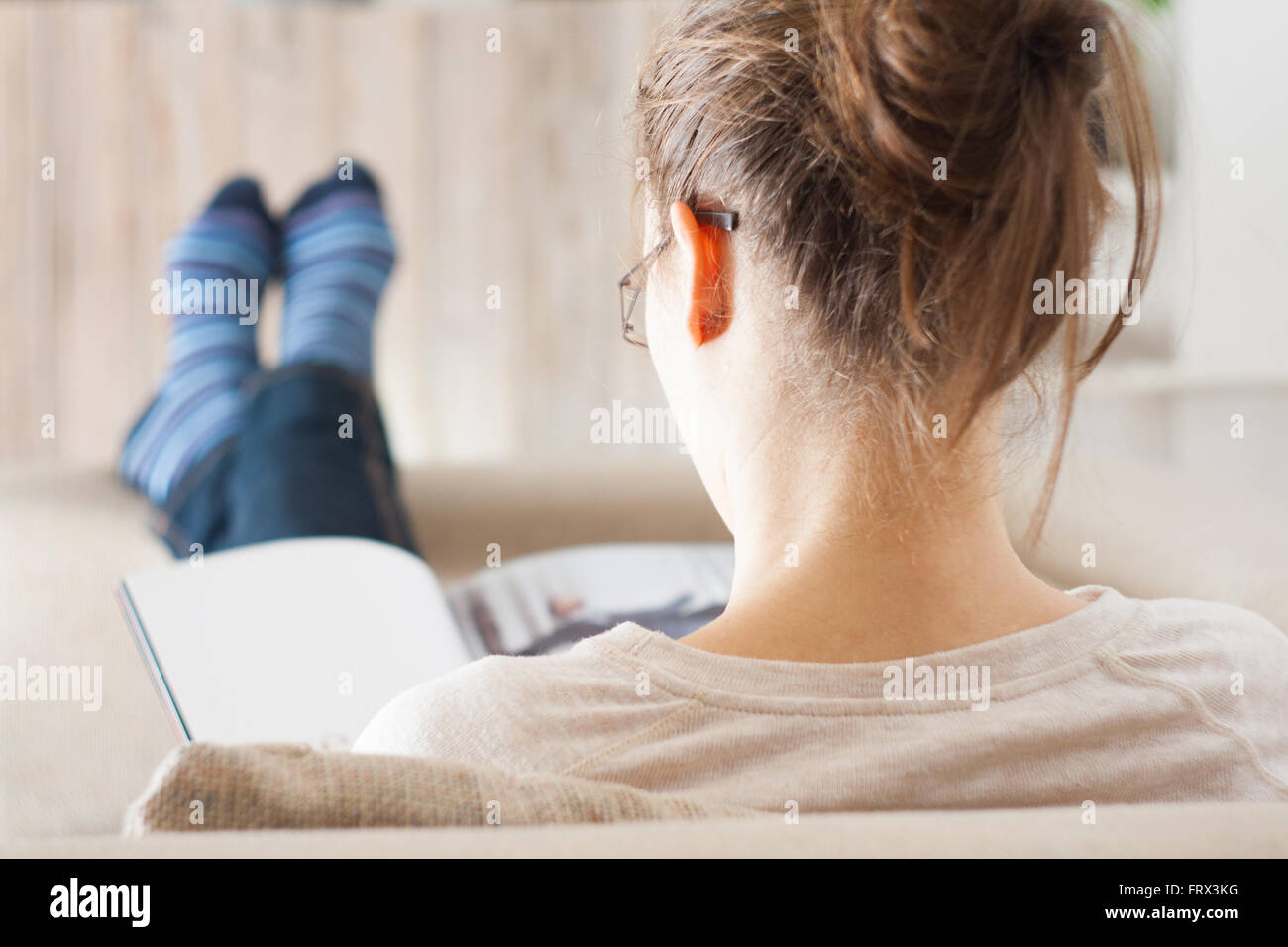 Young woman reading magazine book relaxed in sofa Stock Photo - Alamy