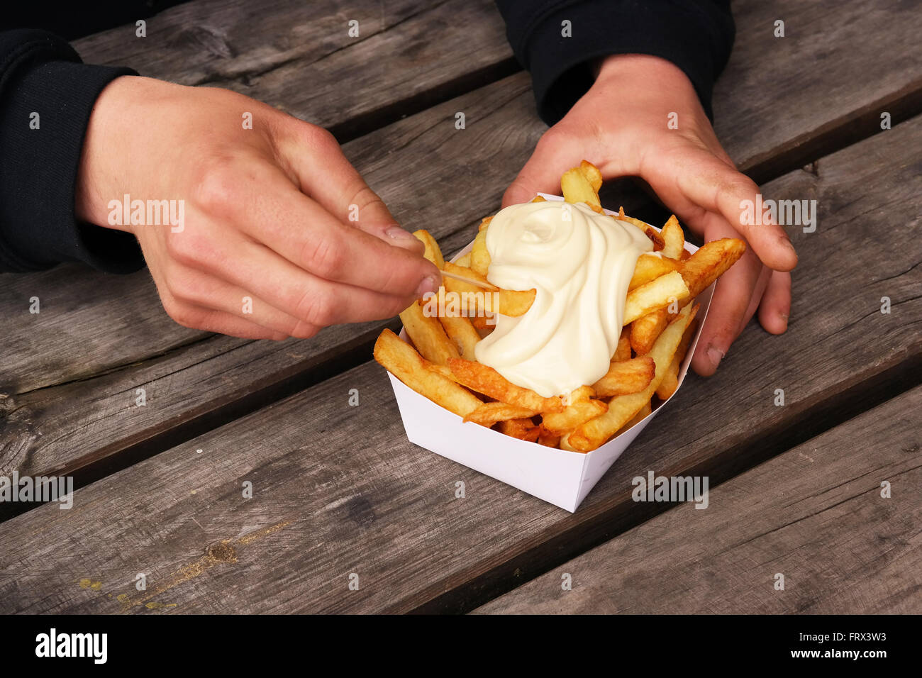 Hands with a tray of Belgian fries and mayonnaise on top Stock Photo ...