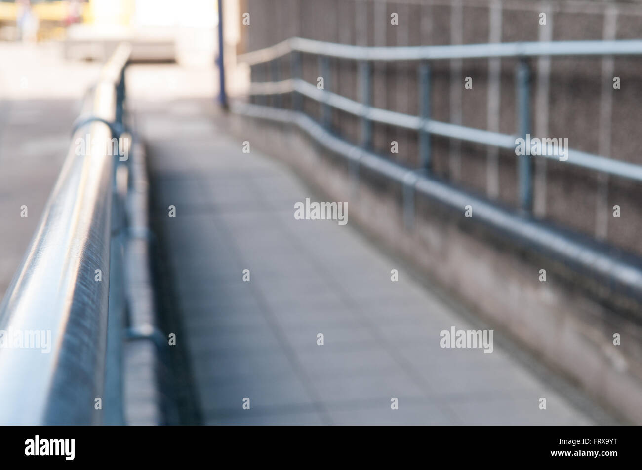 Blurred view down down a city path with a railing Stock Photo - Alamy
