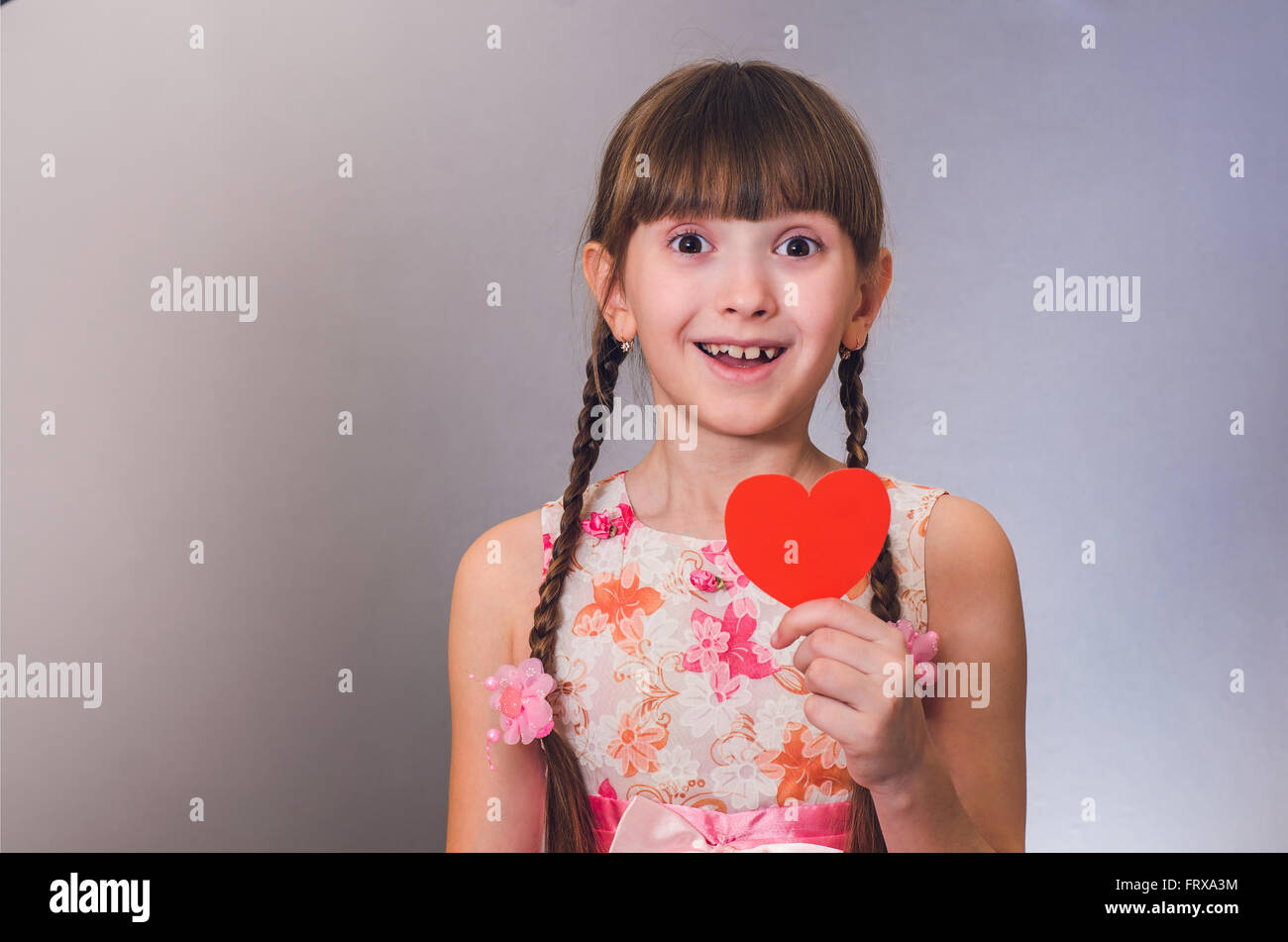 The girl smiles and holds in hand heart Stock Photo - Alamy