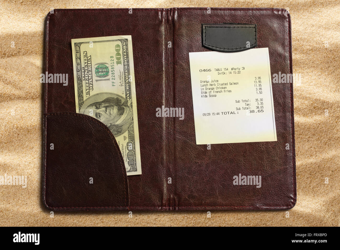 Open check folder with bill and money on sand Stock Photo - Alamy