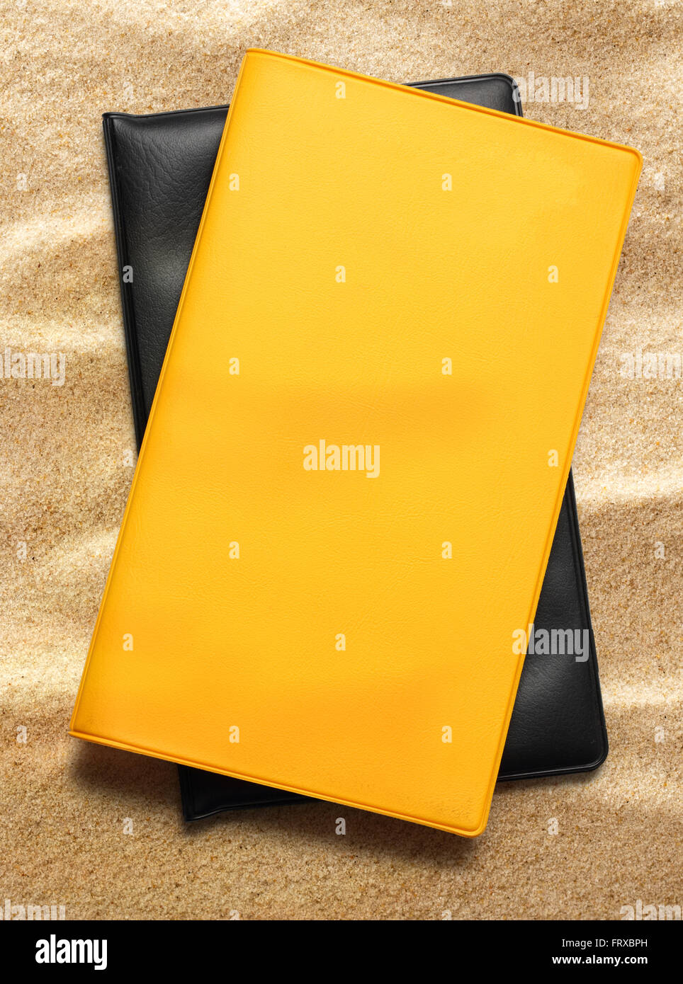 Yellow and black blank books on sand Stock Photo - Alamy