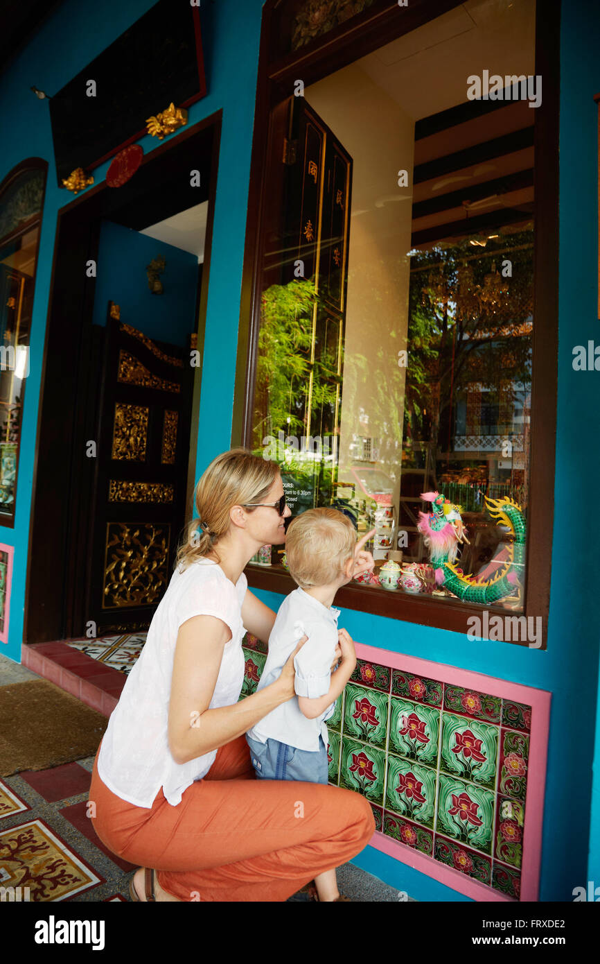 Mother and son looking at a shop window of an antique shop, Chinatown ...