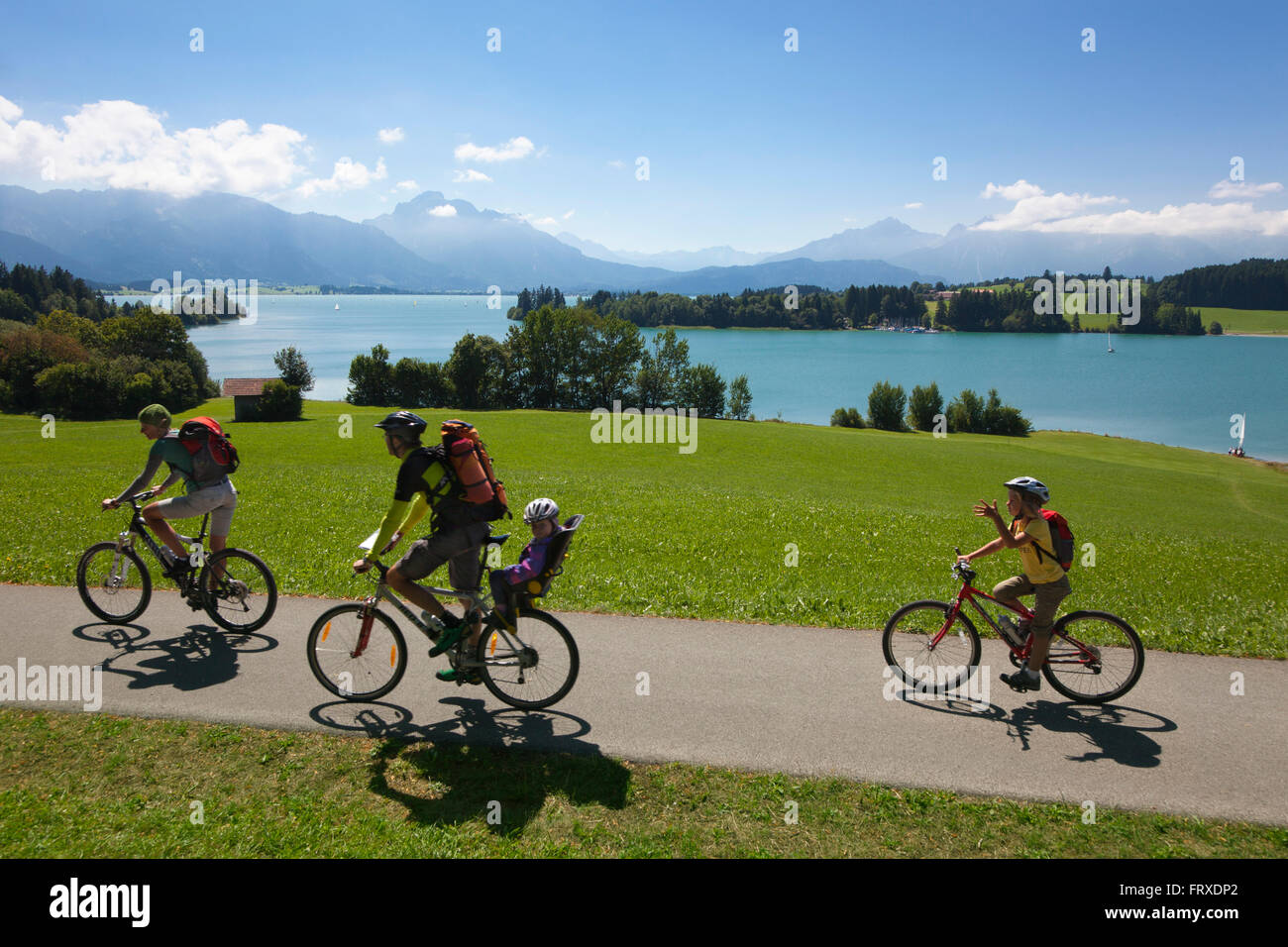 Family with bikes at Forggensee, Allgaeu Alps with Tegelberg, Saeuling ...