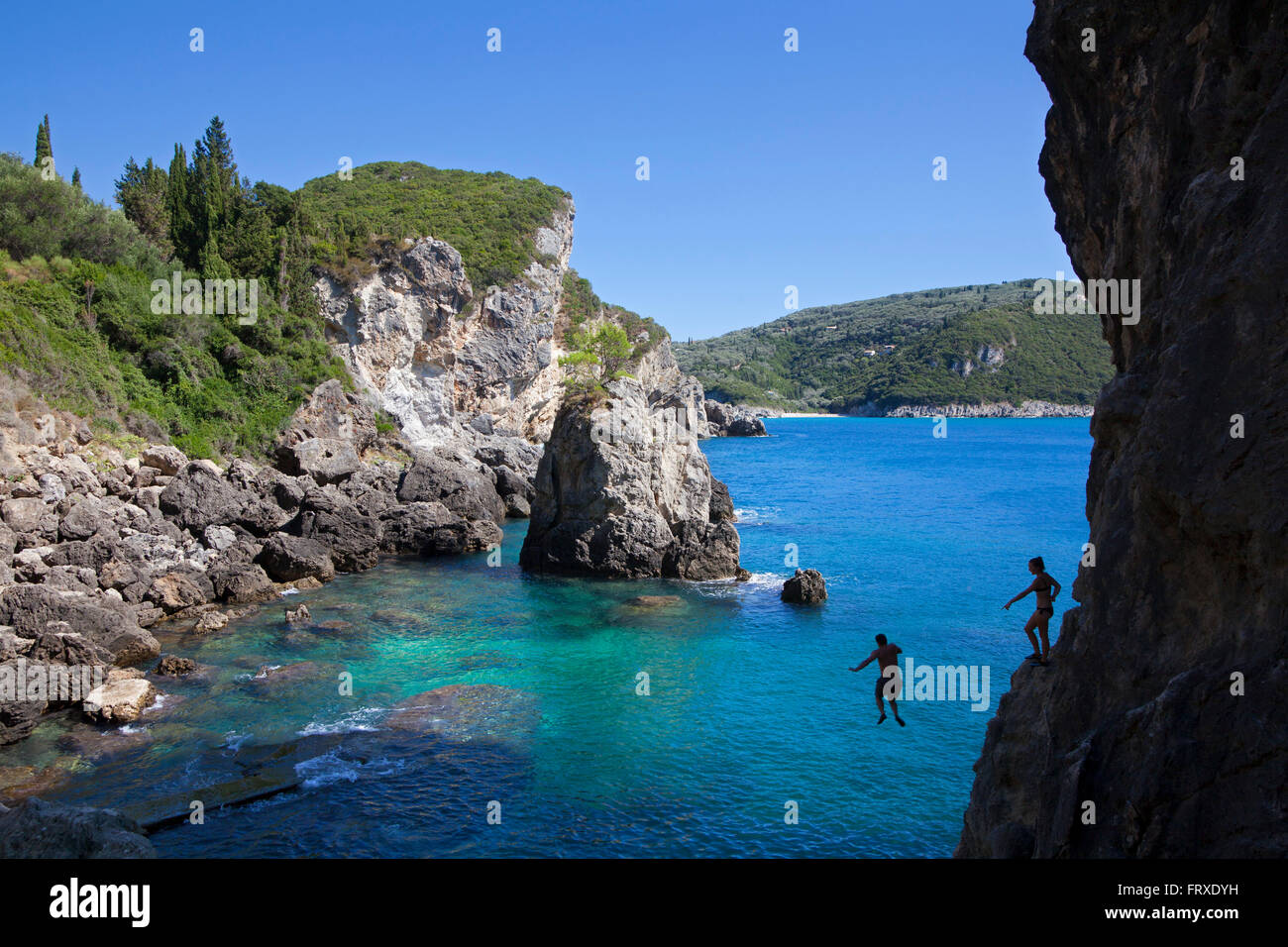 Man jumping from the cliff near the beach bar La Grotta, La Grotta Bay ...