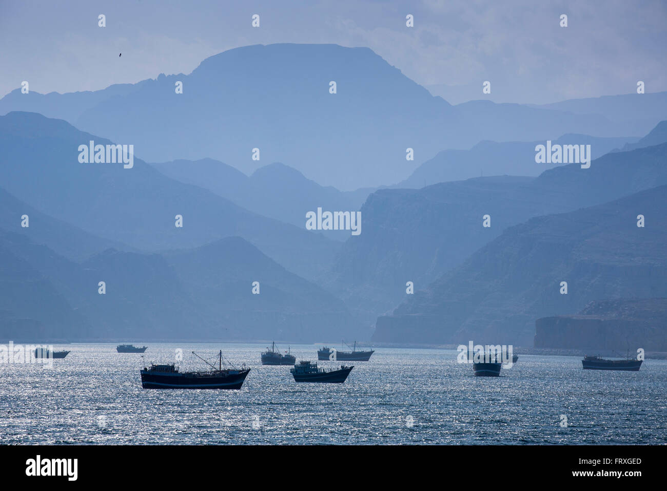 Dhows in the harbor and Musandam Peninsula mountain ranges, Khasab ...