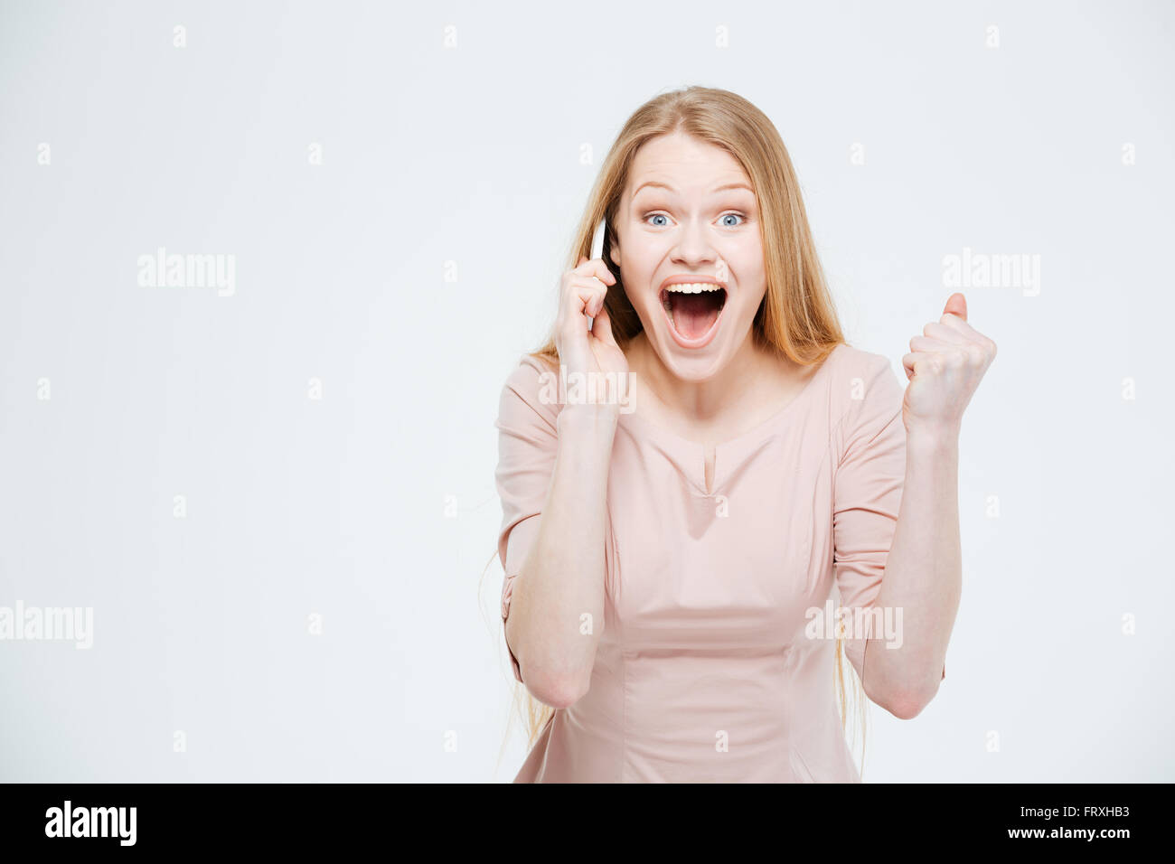 Excited woman talking on the phone isolated on a white background Stock ...
